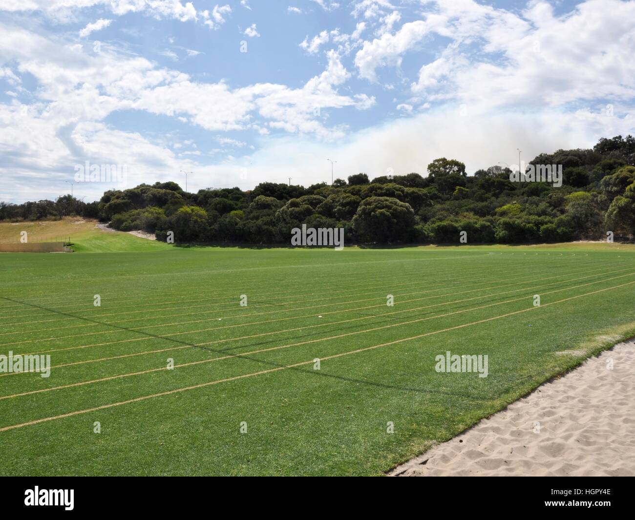 Footy field with green grass and white striped parallel lines ...