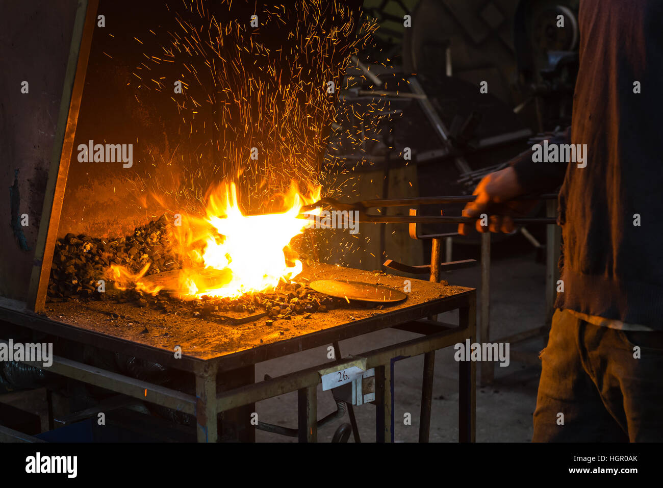 The blacksmith making flames in smithy with spark fireworks Stock Photo ...