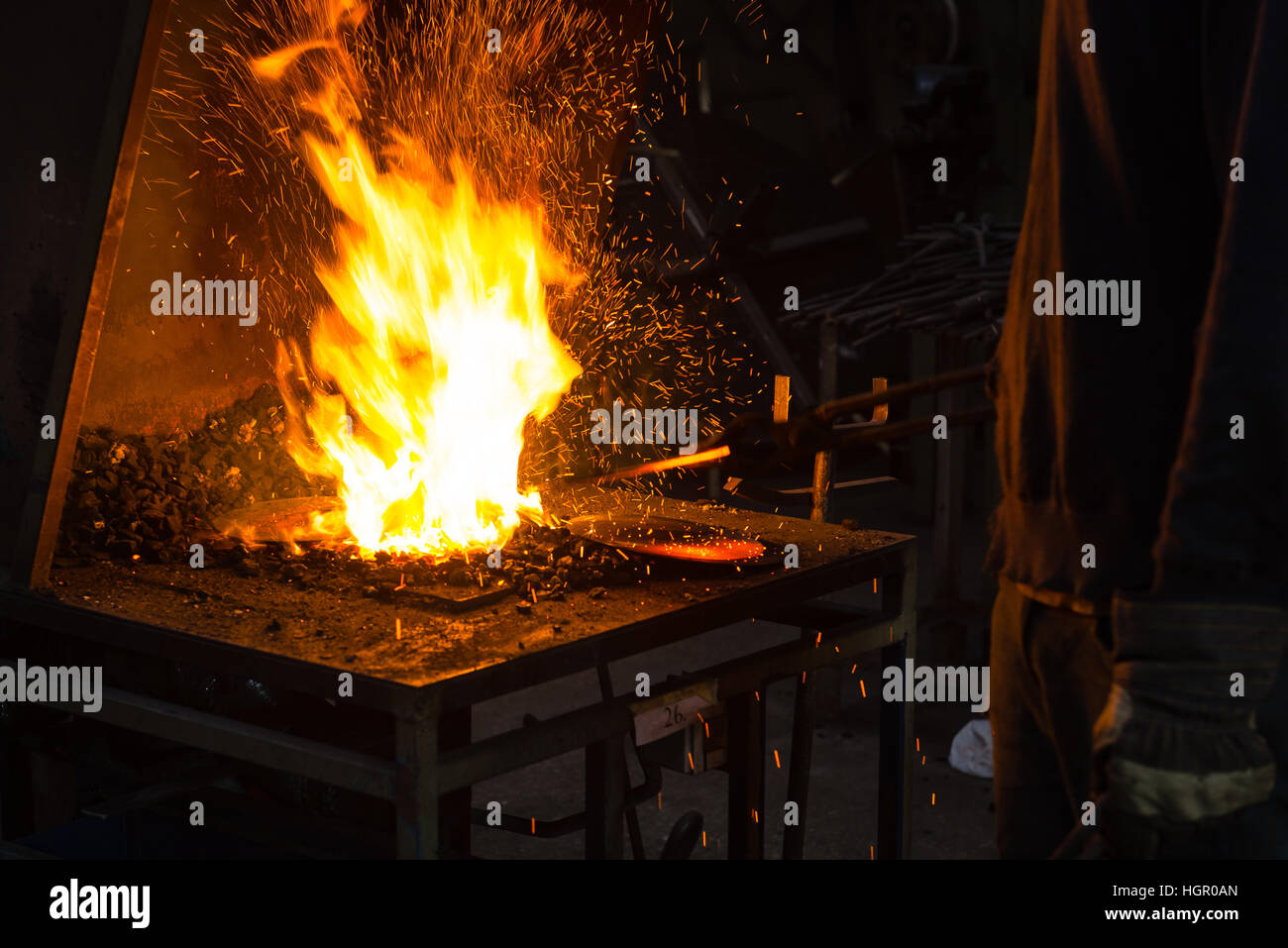 The blacksmith making flames in smithy with spark fireworks Stock Photo ...