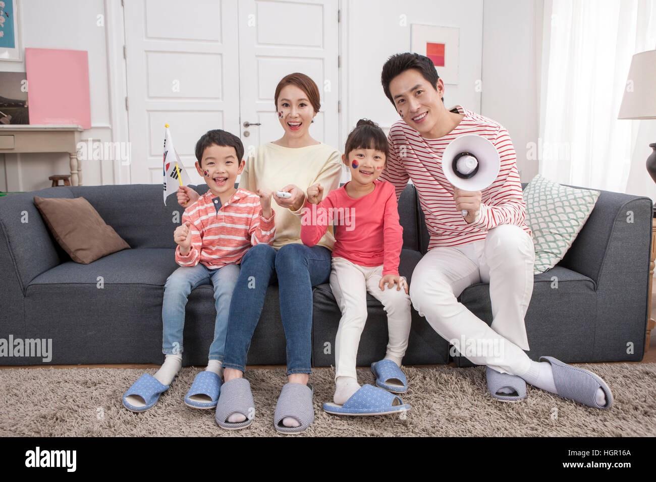 Harmonious family cheering for Korean team Stock Photo - Alamy
