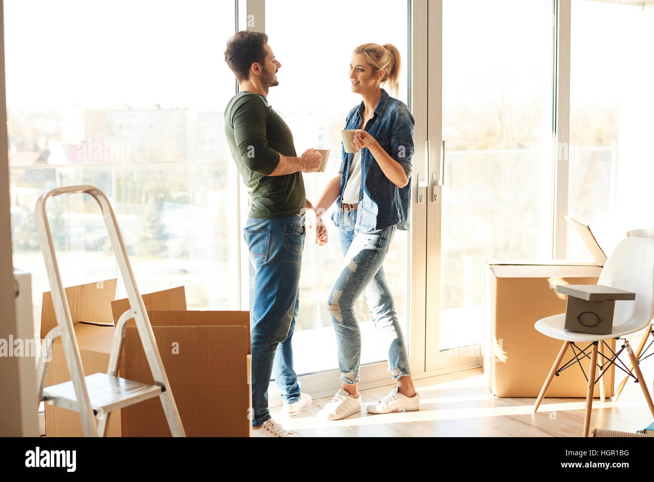 Couple having a coffee break in new house Stock Photo - Alamy