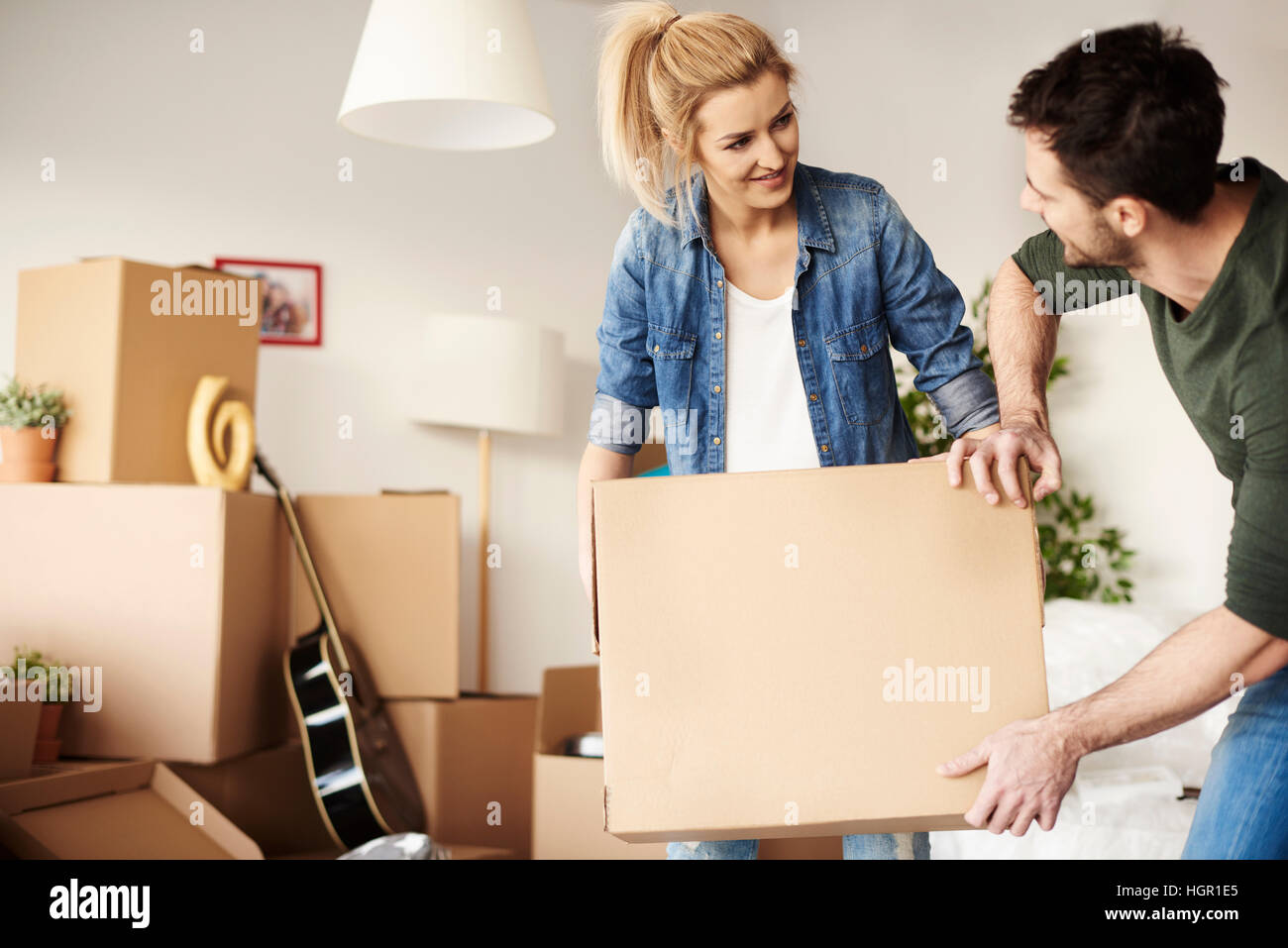Man helping woman carrying the cardboard box Stock Photo - Alamy