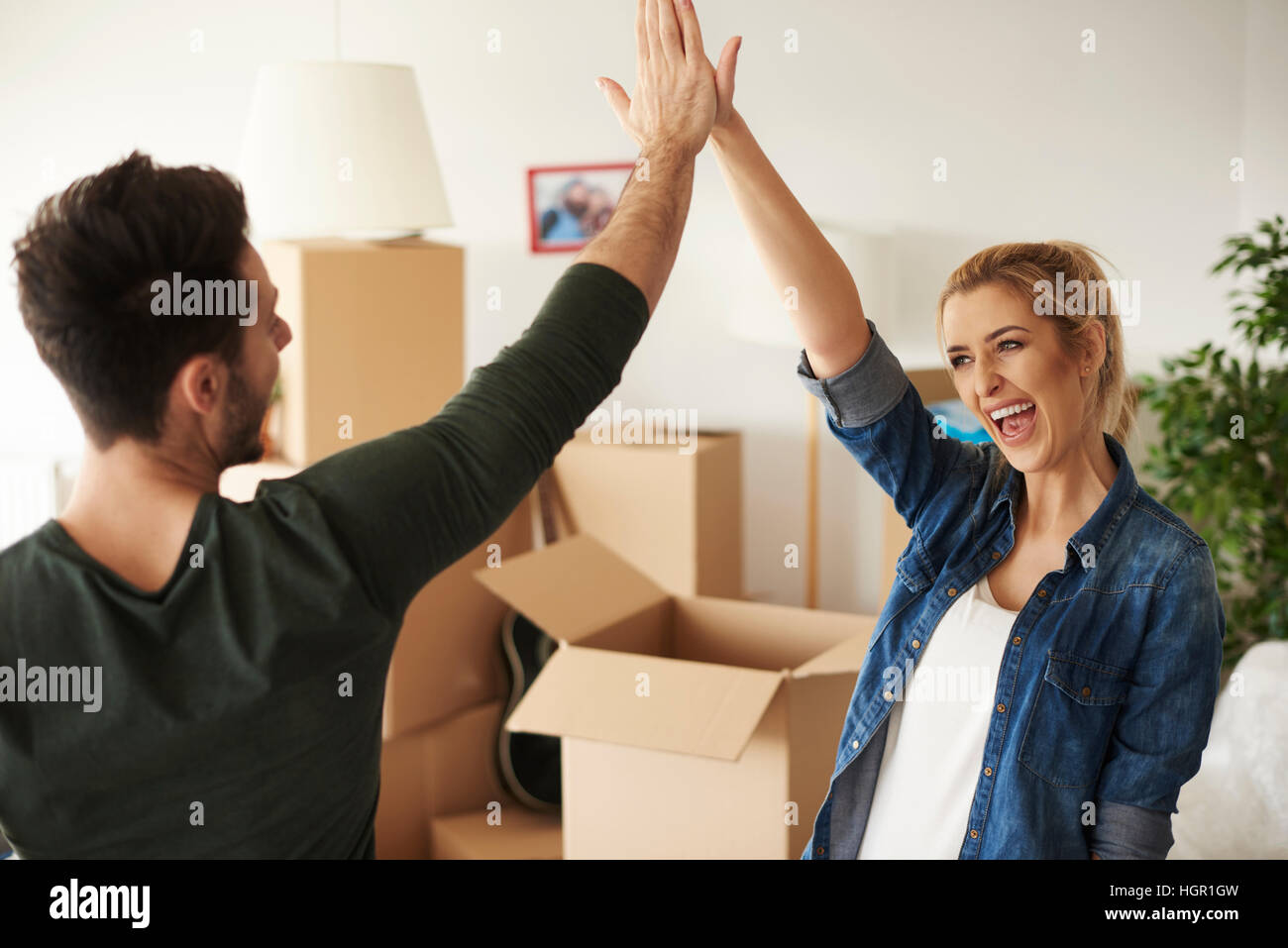 Happy and young couple giving high five Stock Photo - Alamy