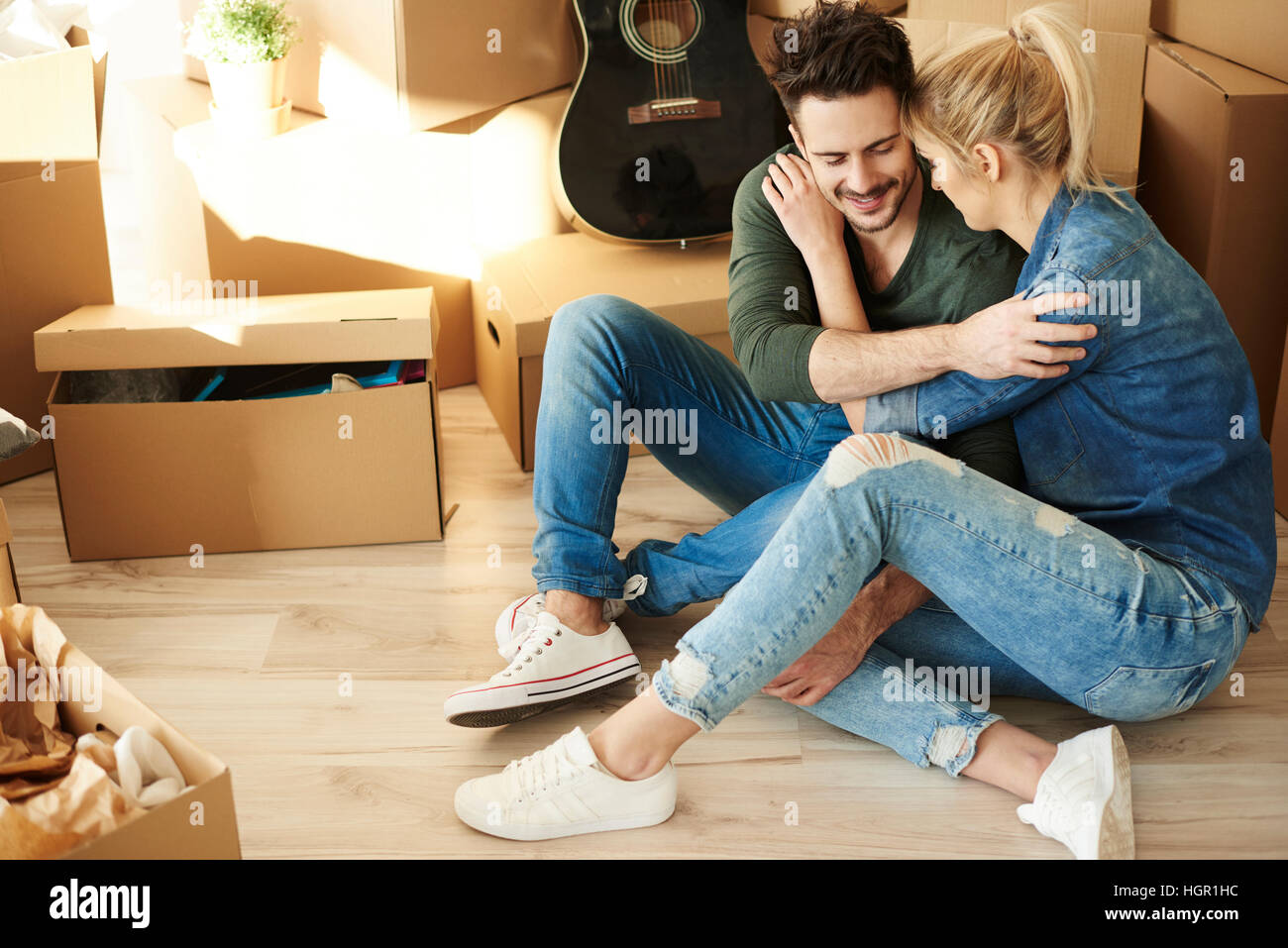 Couple having a rest among the cardboard boxes Stock Photo - Alamy