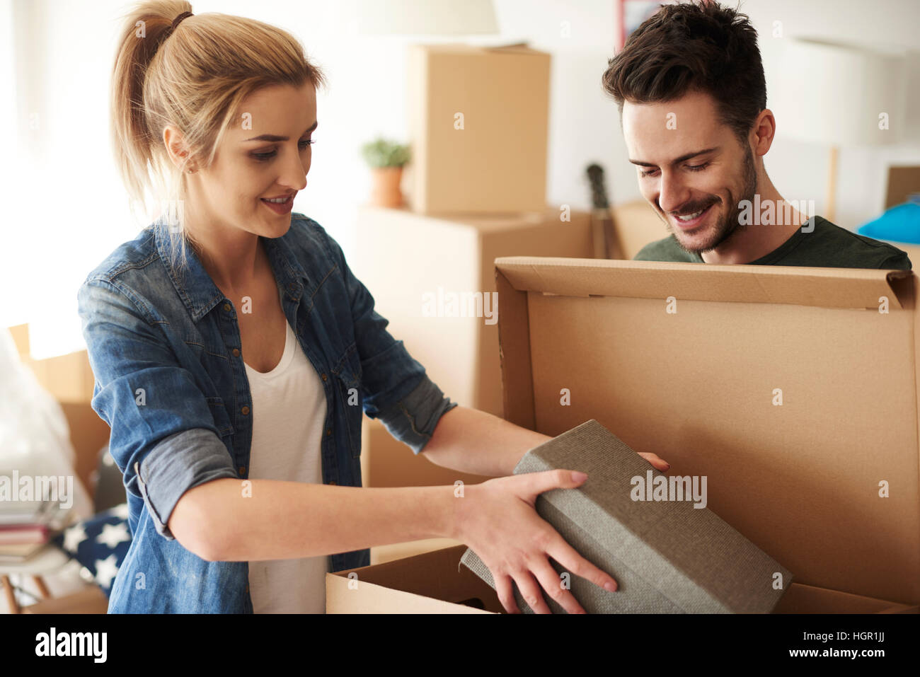 Couple organizing stuff from cardboard boxes Stock Photo - Alamy