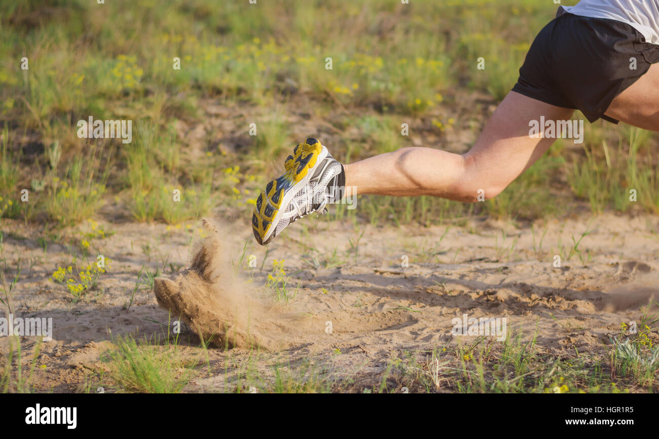 Athlete's foot in sneakers which starts to run. Sand flies under their ...