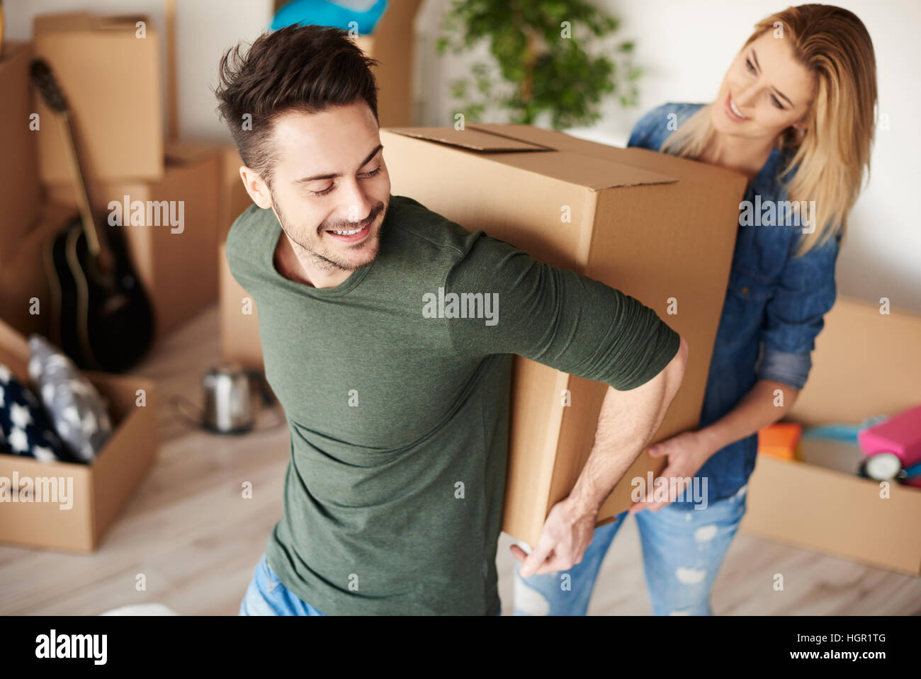 Couple carrying heavy moving boxes together Stock Photo - Alamy