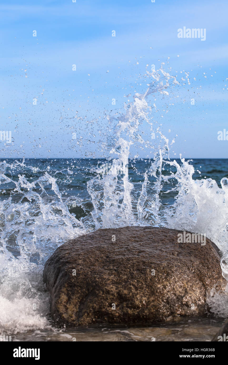 Ocean wave splashing when hit at a large stone in the water Stock Photo ...