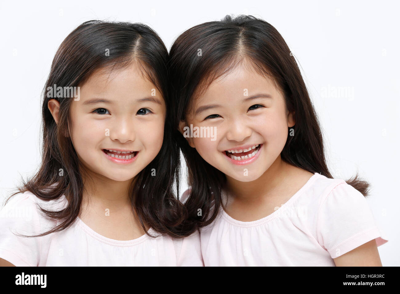 Portrait of smiling twin girls Stock Photo - Alamy