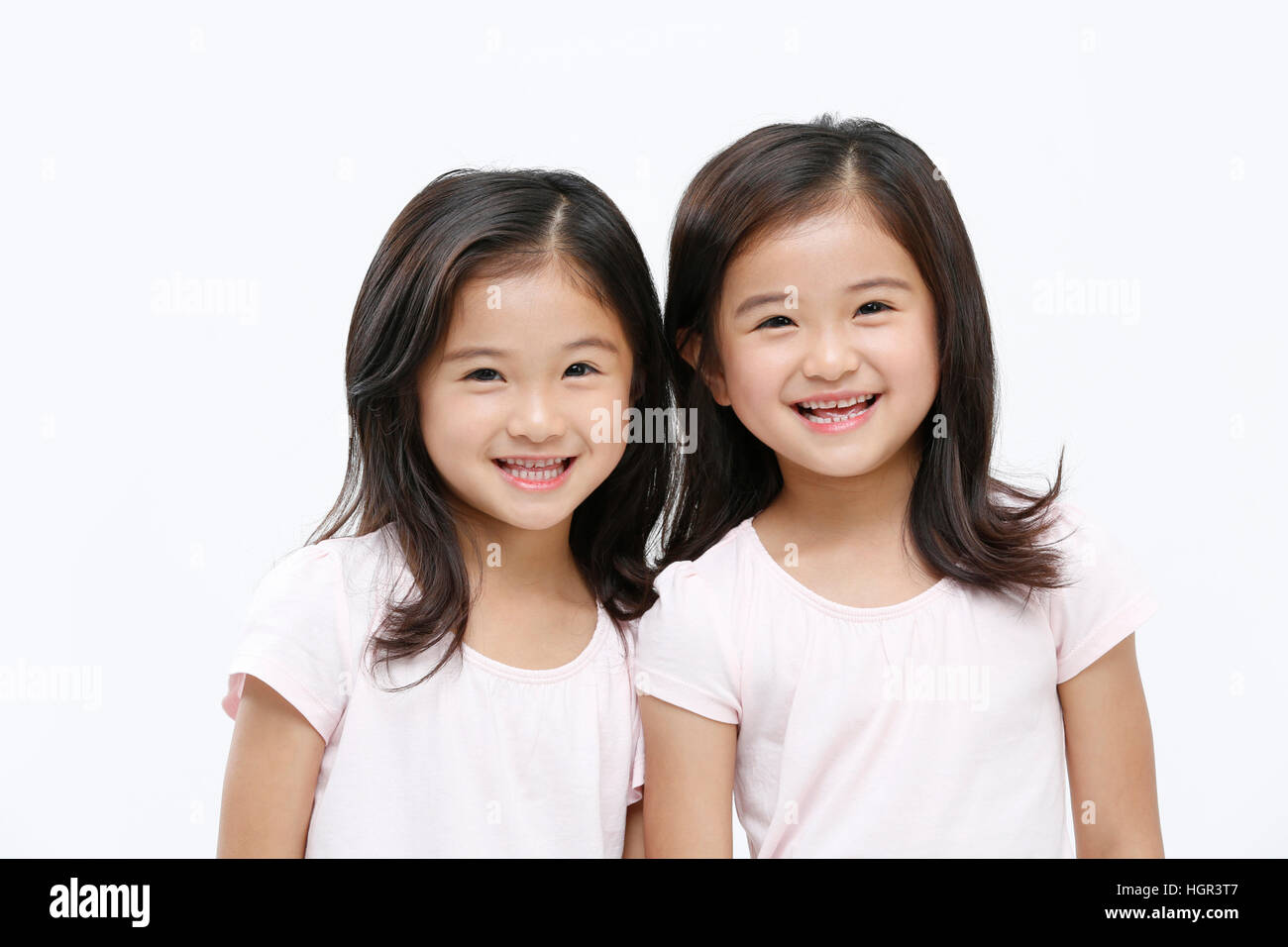 Portrait of smiling twin girls Stock Photo - Alamy