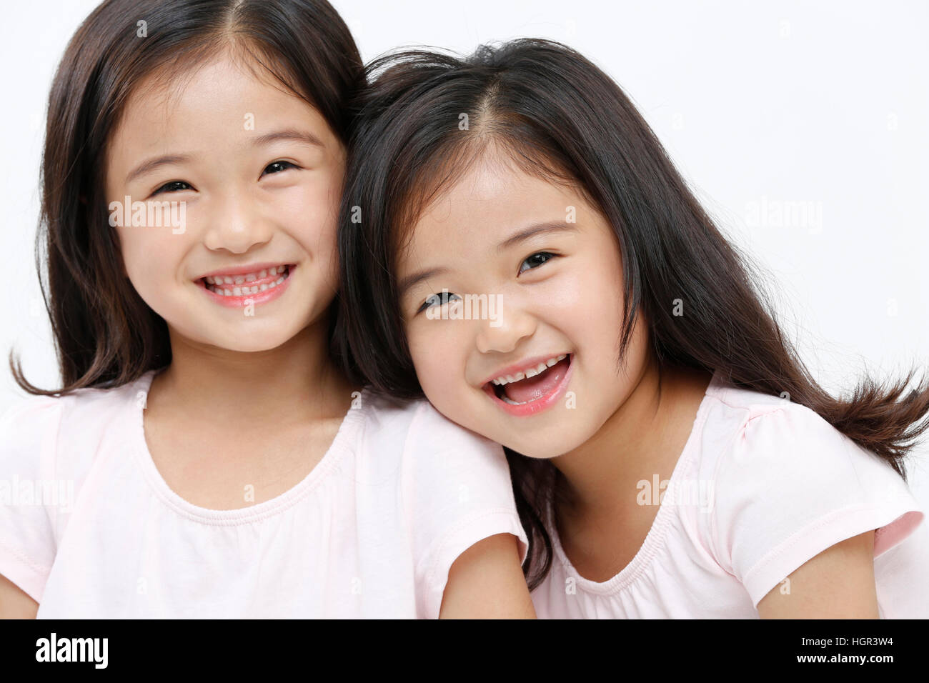 Portrait of smiling twin girls Stock Photo - Alamy