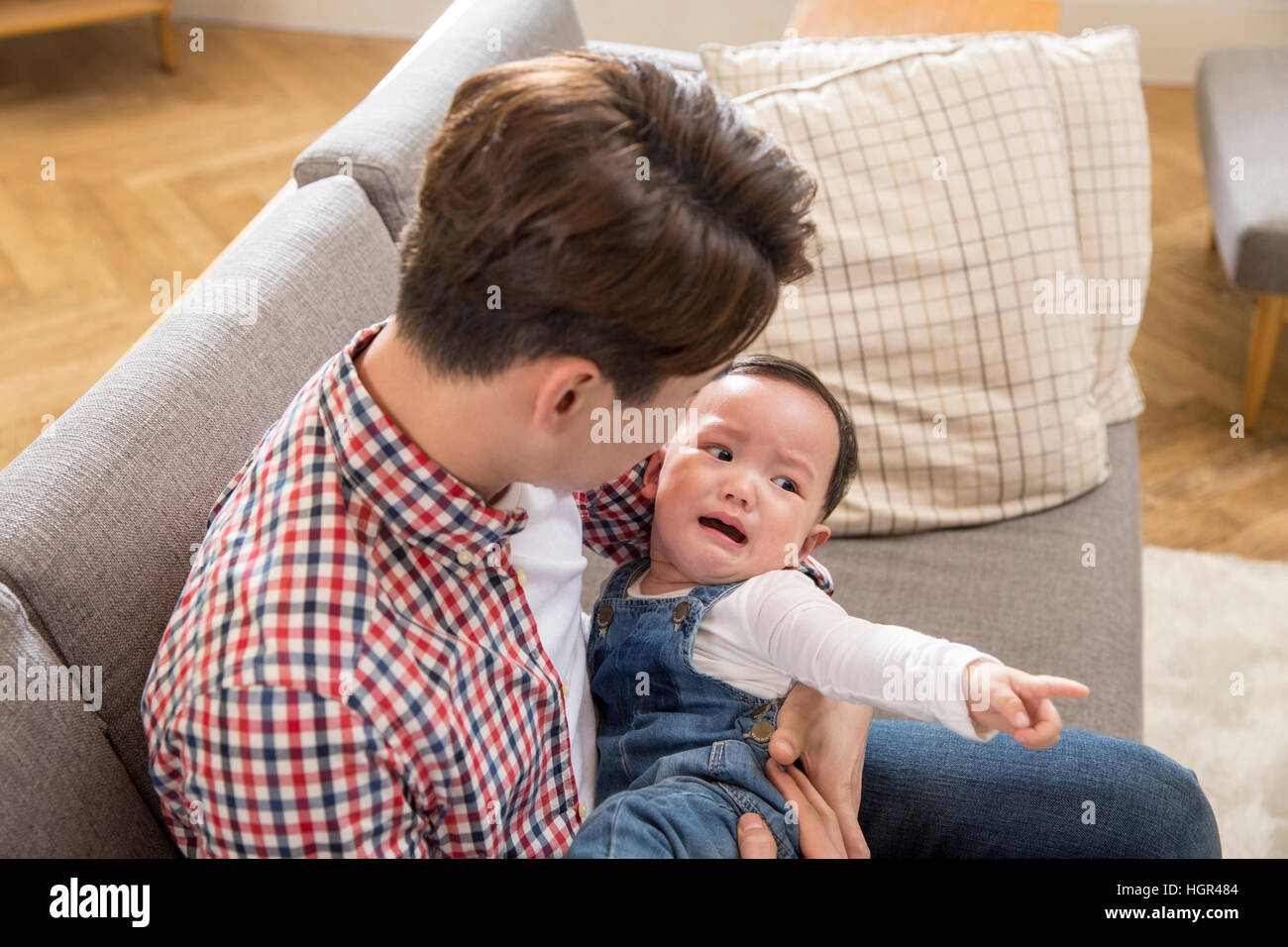 Father holding crying baby son Stock Photo - Alamy