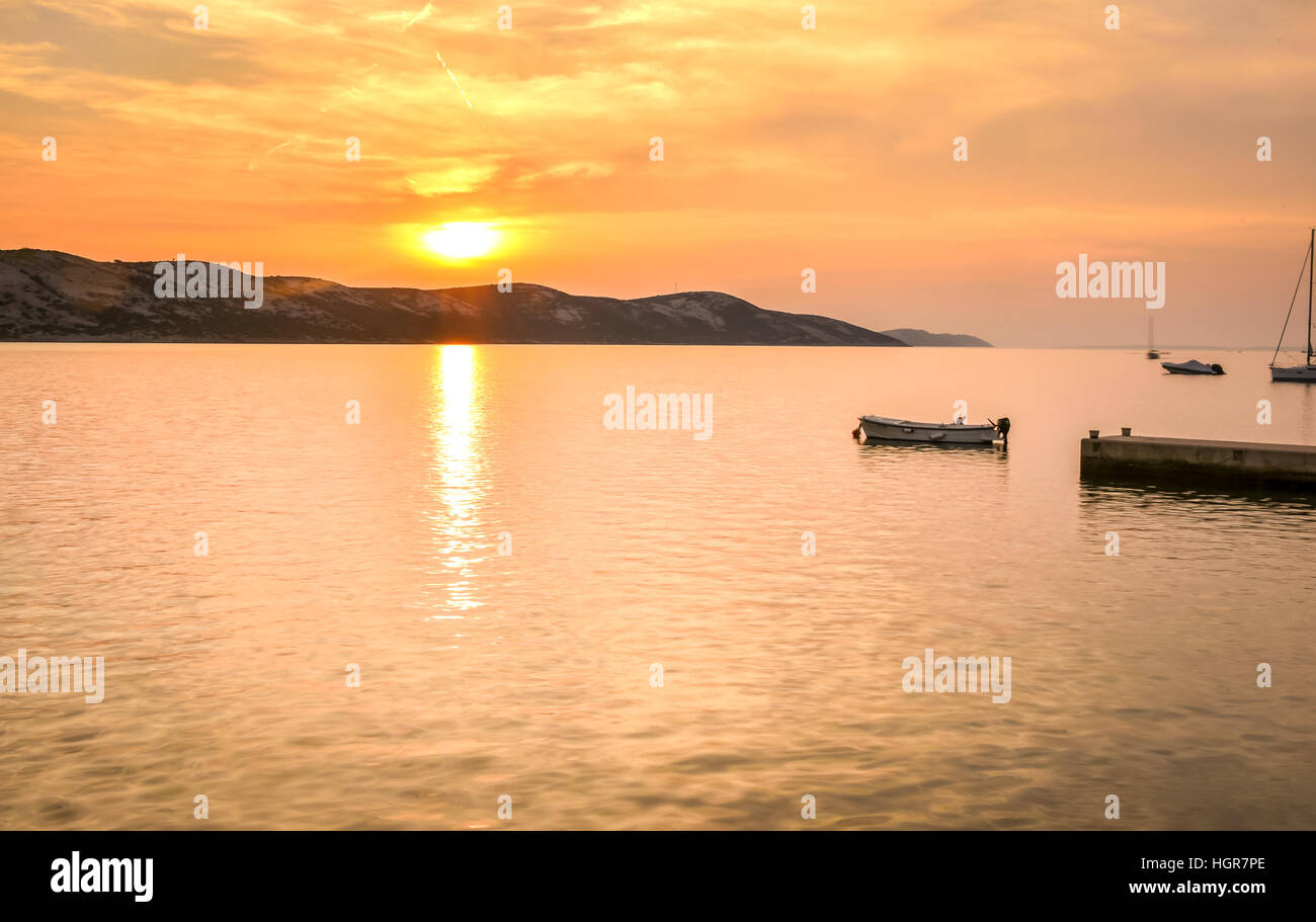 Peaceful sunset or sunrise by the sea with boats and sailship ...