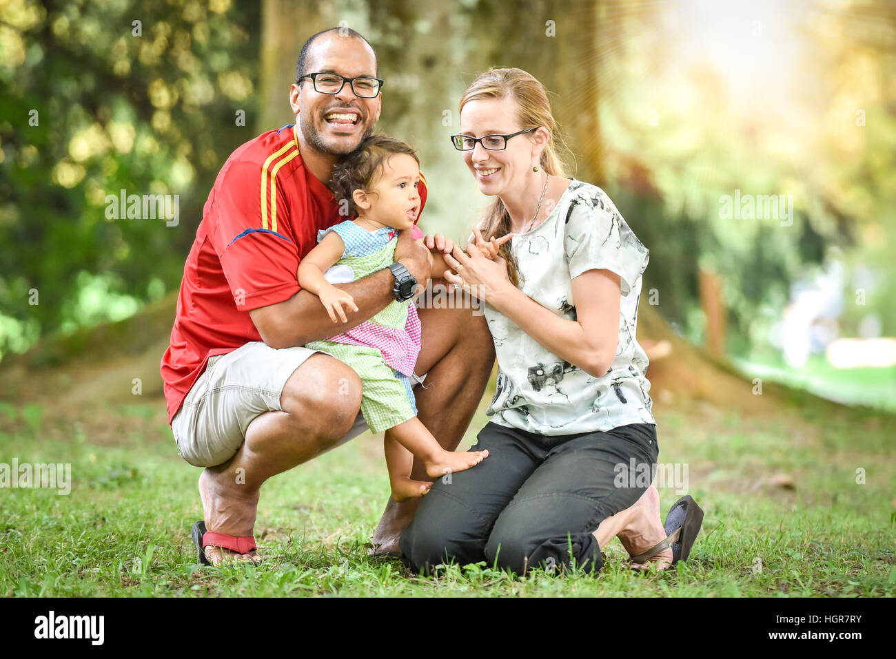 Happy interracial family is enjoying a day in the park Stock Photo - Alamy