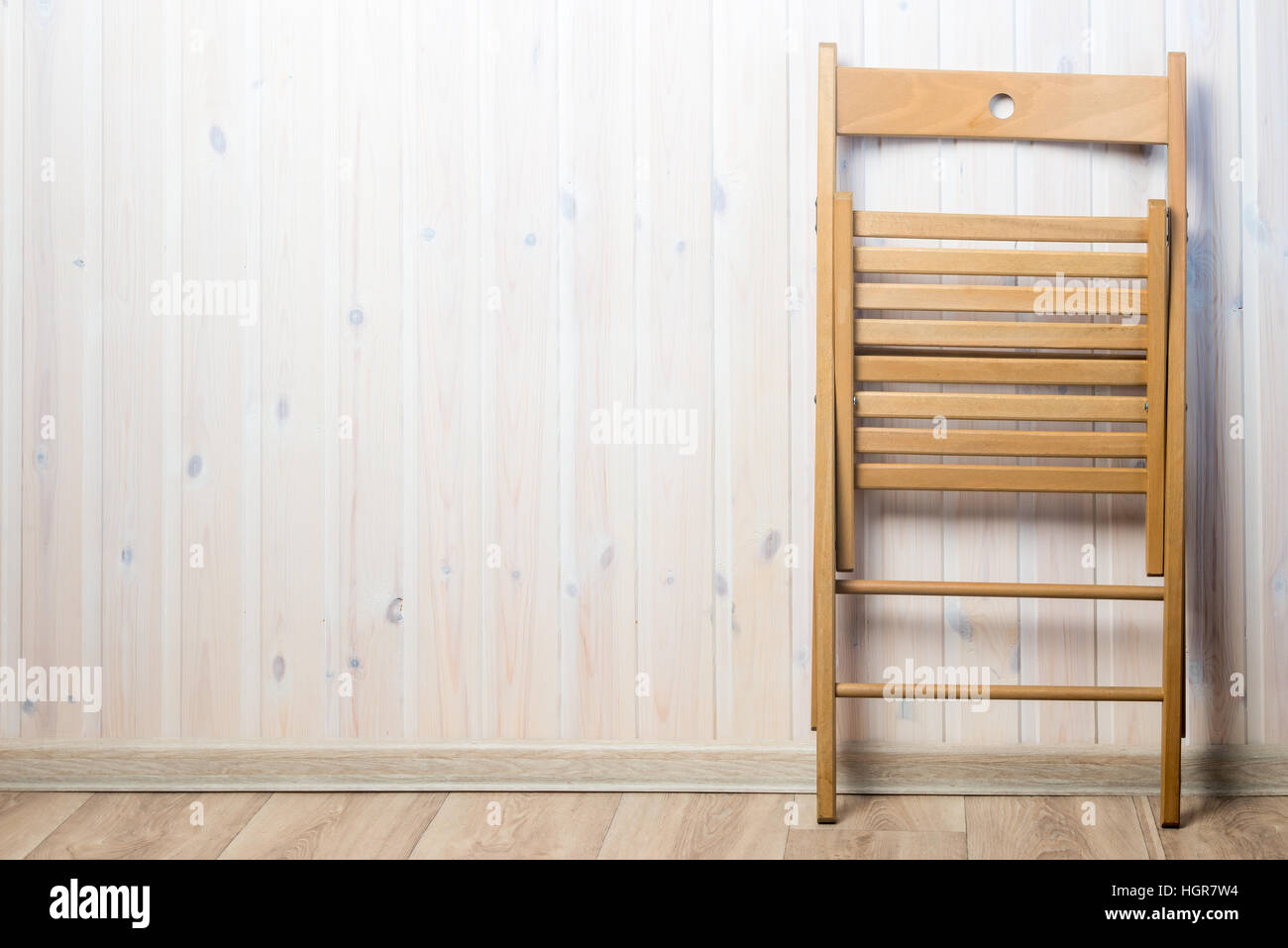 wooden folding chair near the wall, the left space Stock Photo - Alamy
