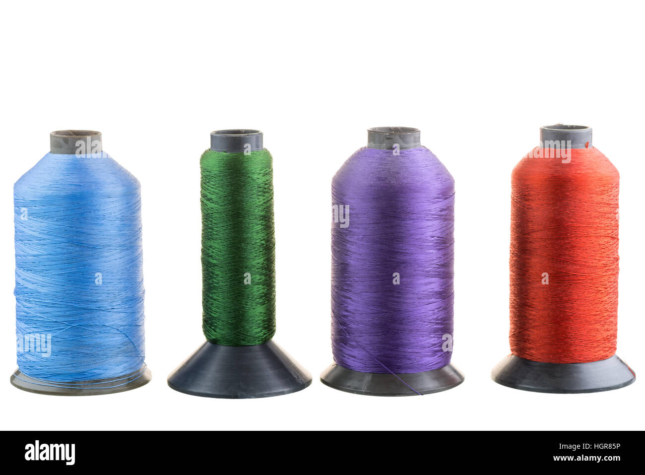 Four spools of silk thread in a row isolated Stock Photo - Alamy