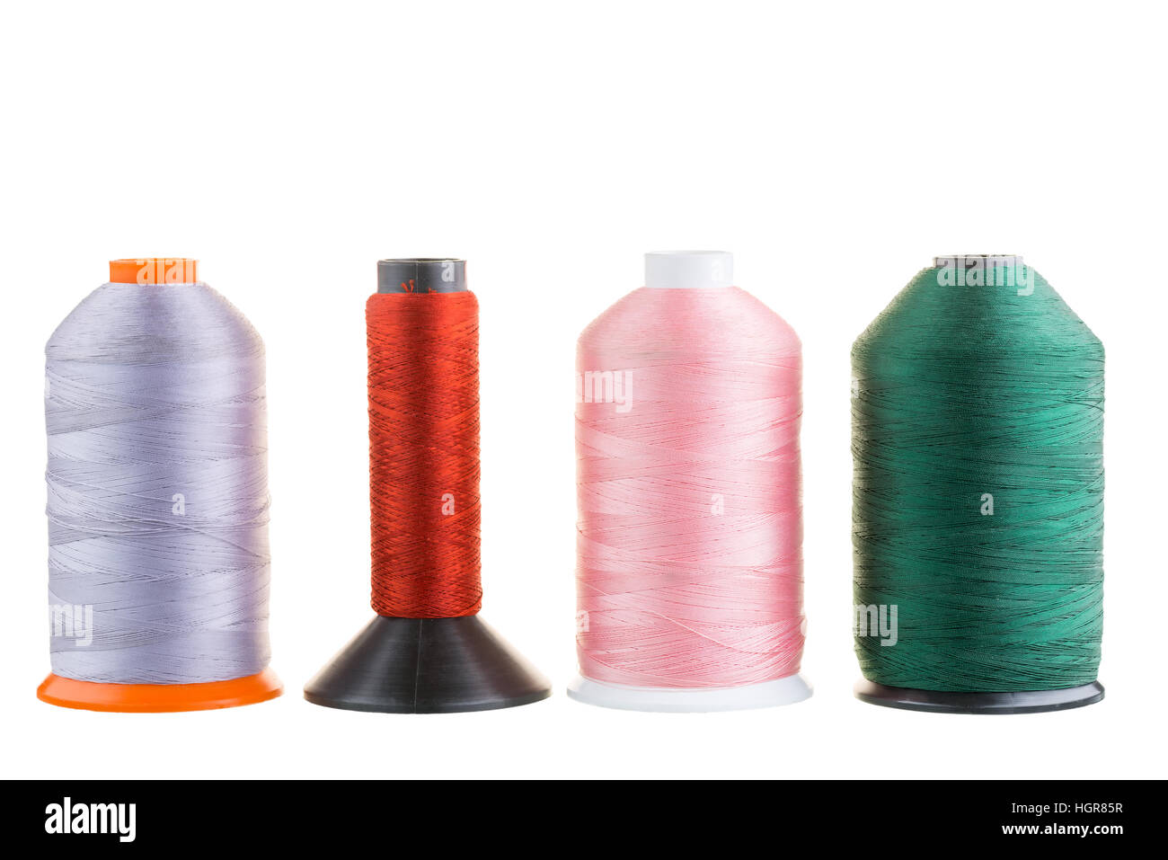 spools of silk thread in a row isolated Stock Photo - Alamy