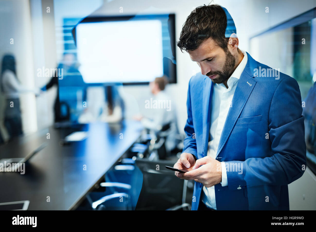 Professional businessman using smartphone in modern office Stock Photo ...