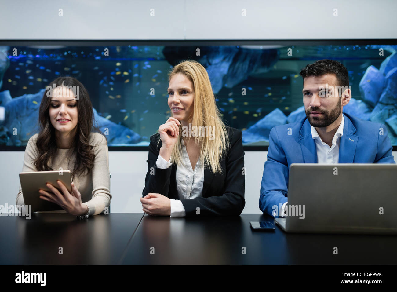 Business people at conference desk with tablet and laptop Stock Photo ...