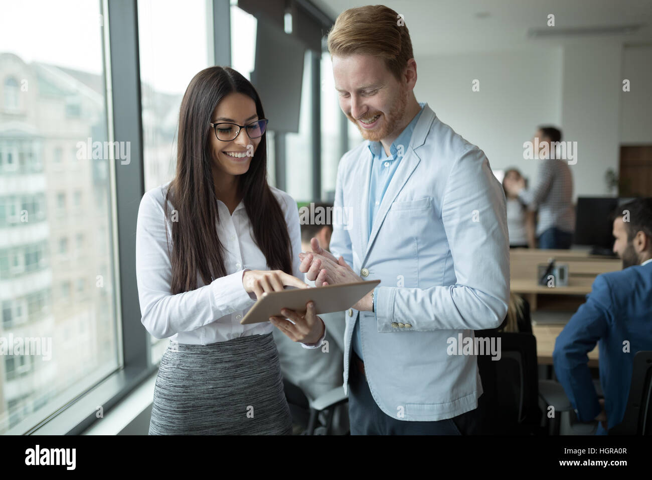 Happy cheerful business colleagues talking in modern IT office Stock ...