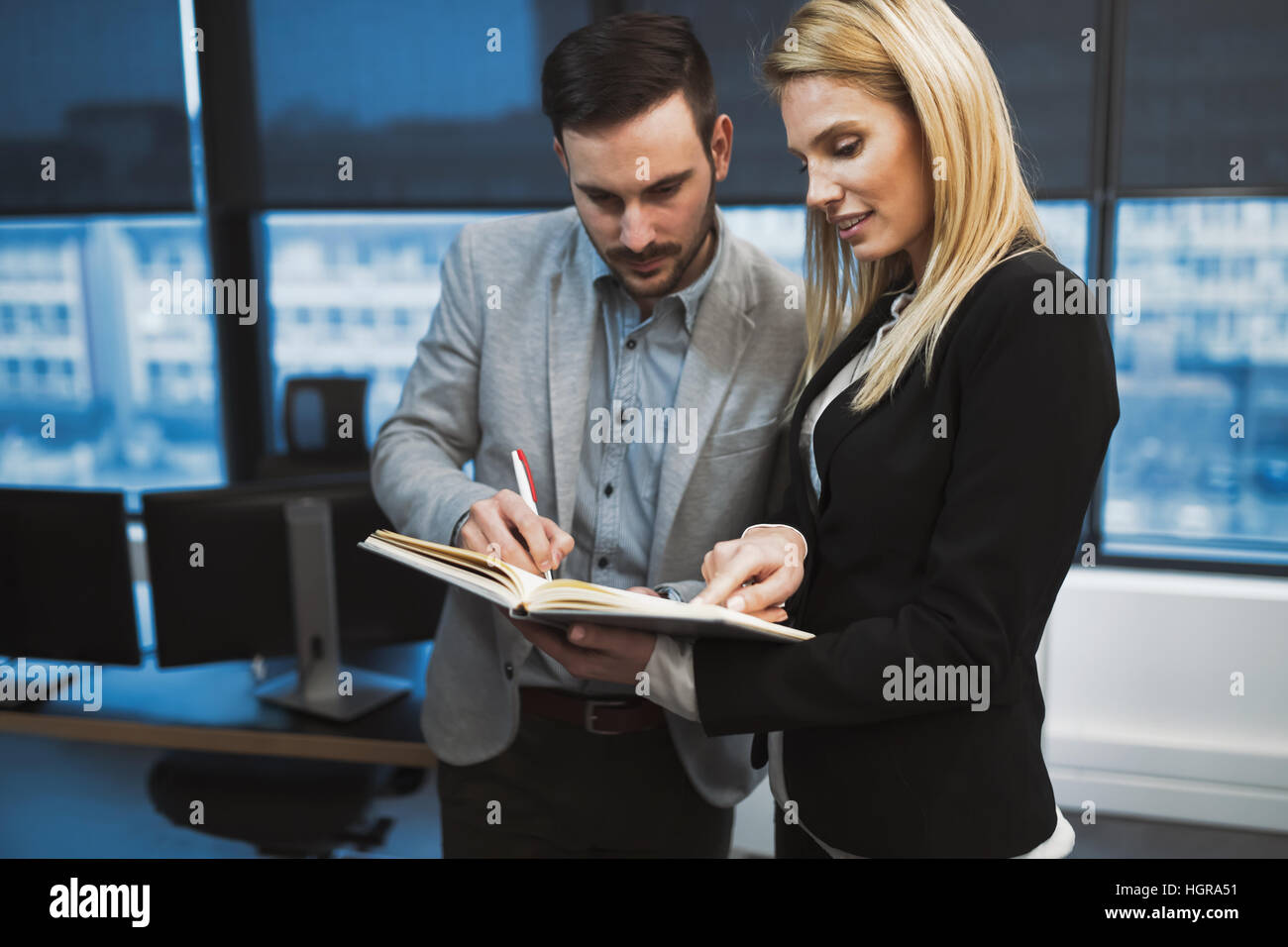 Blond secretary helping boss in office at workplace Stock Photo - Alamy