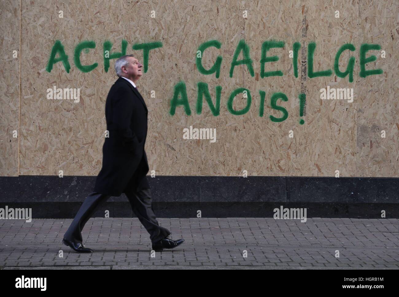 A man walks past graffiti calling for an Irish Language act as An Dream ...