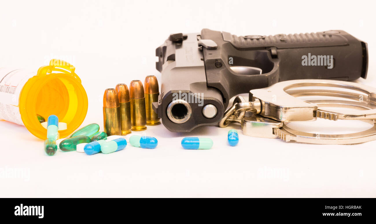 Prescription bottle, drugs, gun, handcuffs and bullets with a white ...