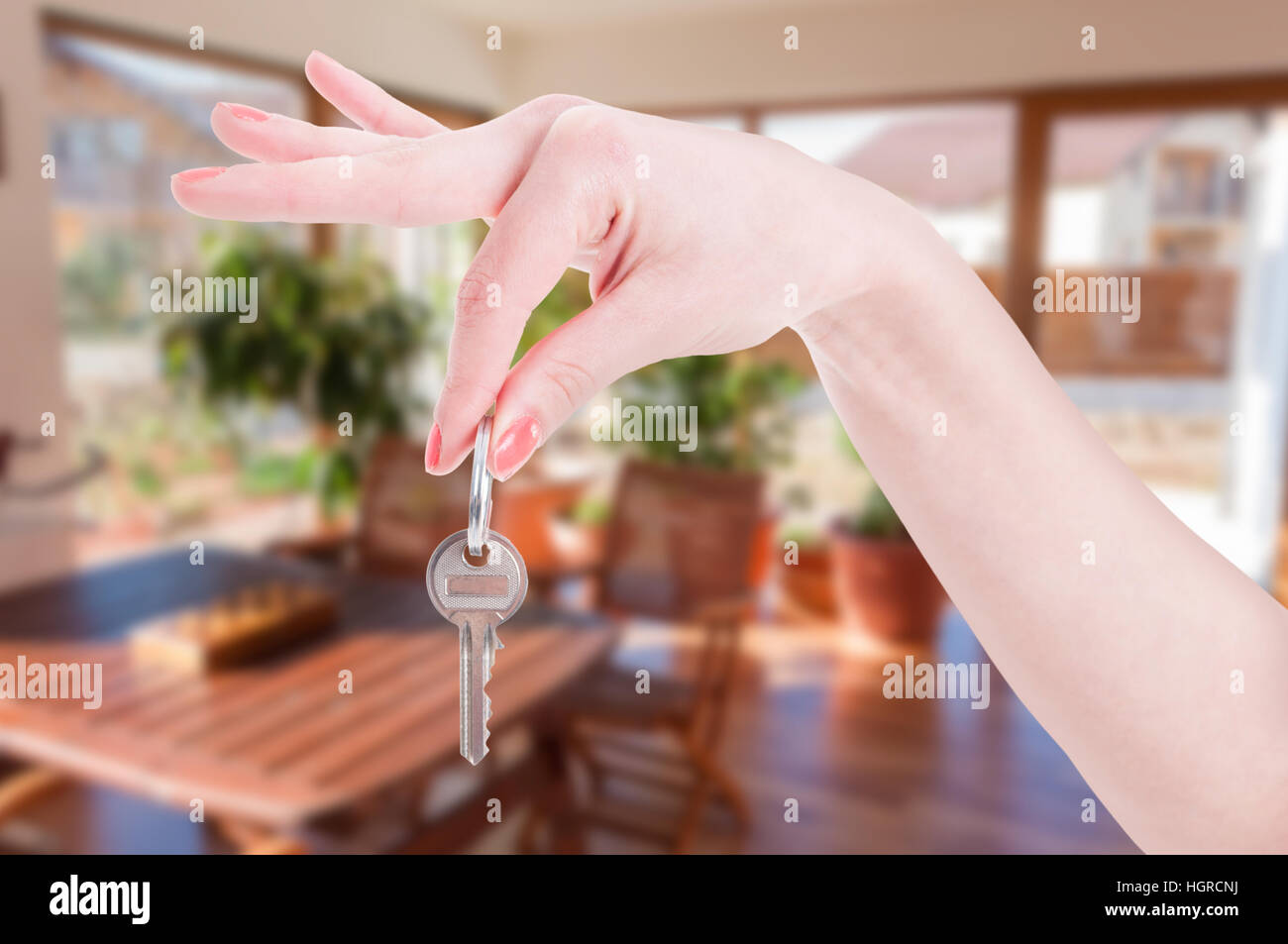 Close-up of female hand holding house key inside of rented property as ...