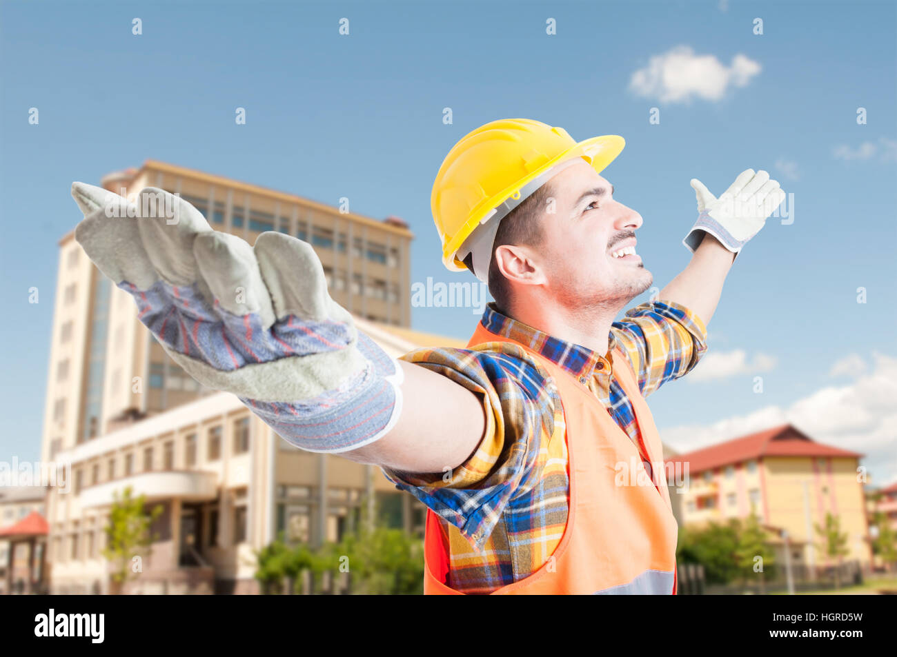 Young engineer or architect standing outdoors with arms outstretched ...