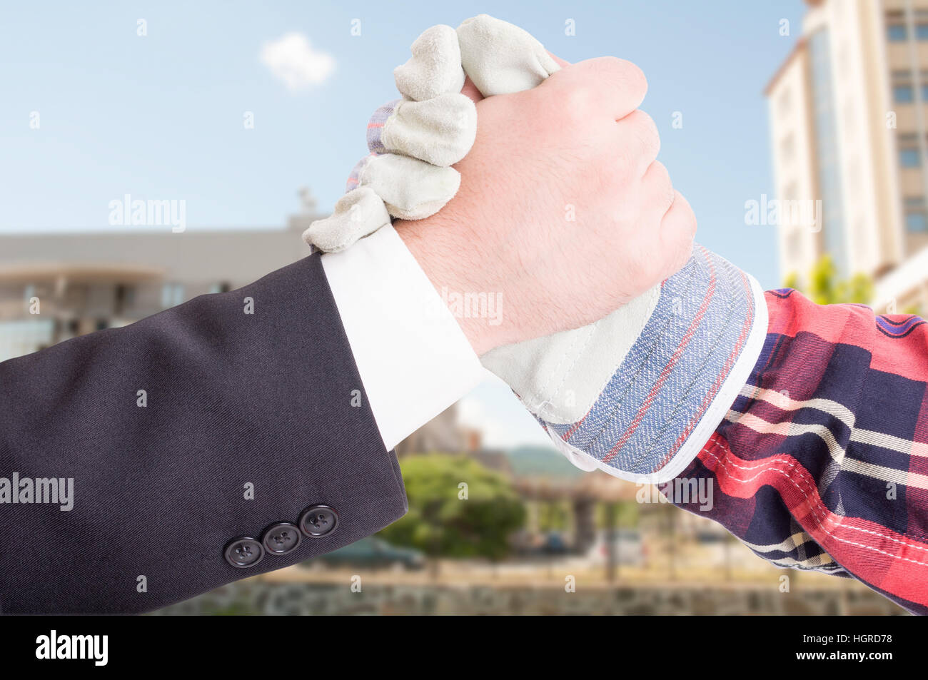 Businessman hand shake with engineer in closeup in front of new ...