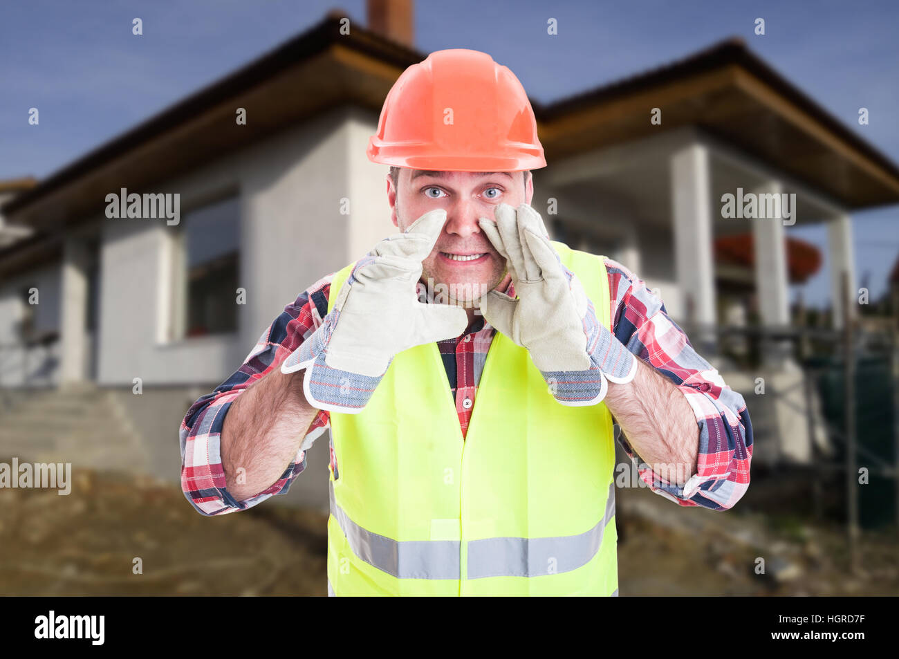 Constructor on construction site with protection equipment screaming or ...