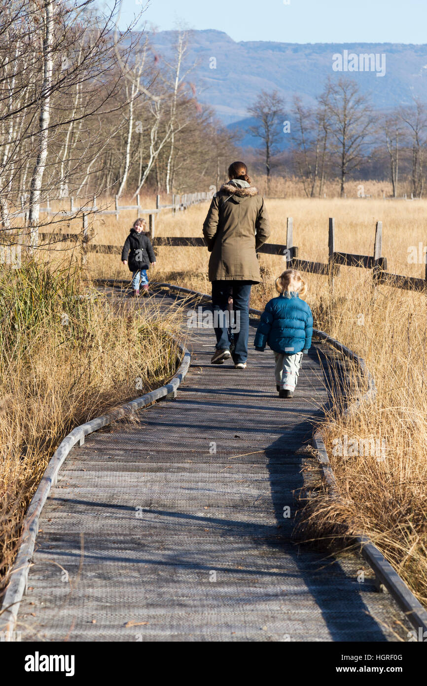 Mother & 3 children three kids daughters on walkway pathway foot path ...