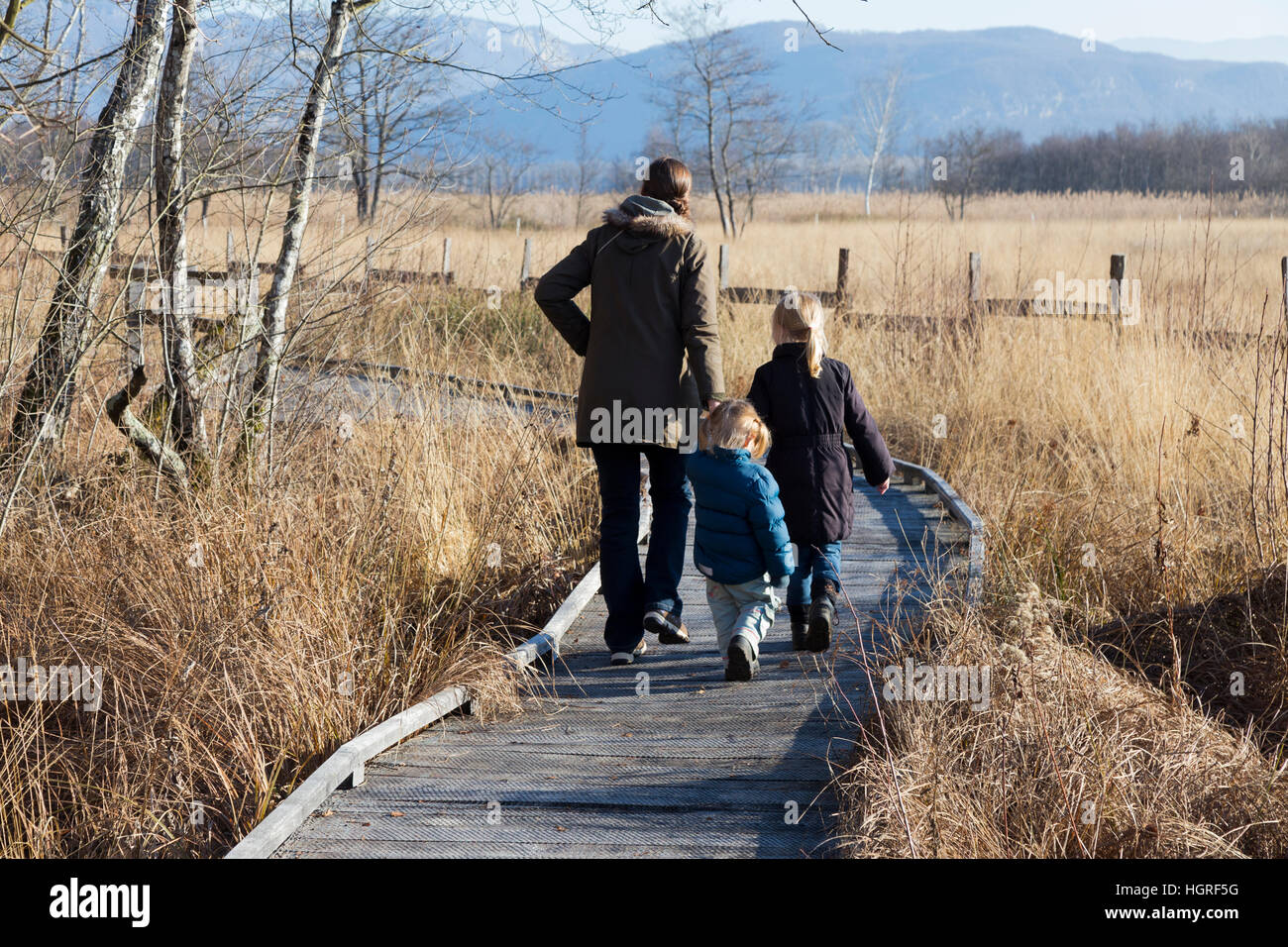 Mother & 3 children three kids daughters on walkway pathway foot path ...