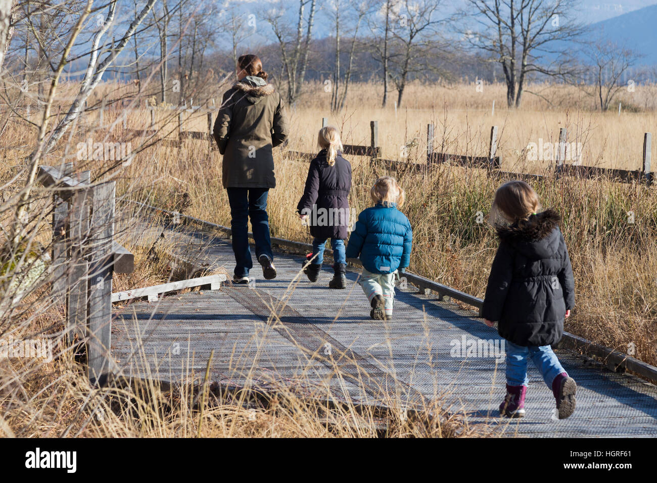 Mother & 3 children three kids daughters on walkway pathway foot path ...
