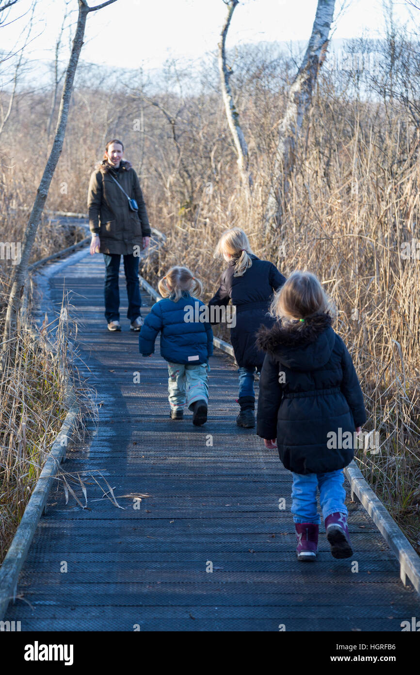 Mother & 3 children three kids daughters on walkway pathway foot path ...