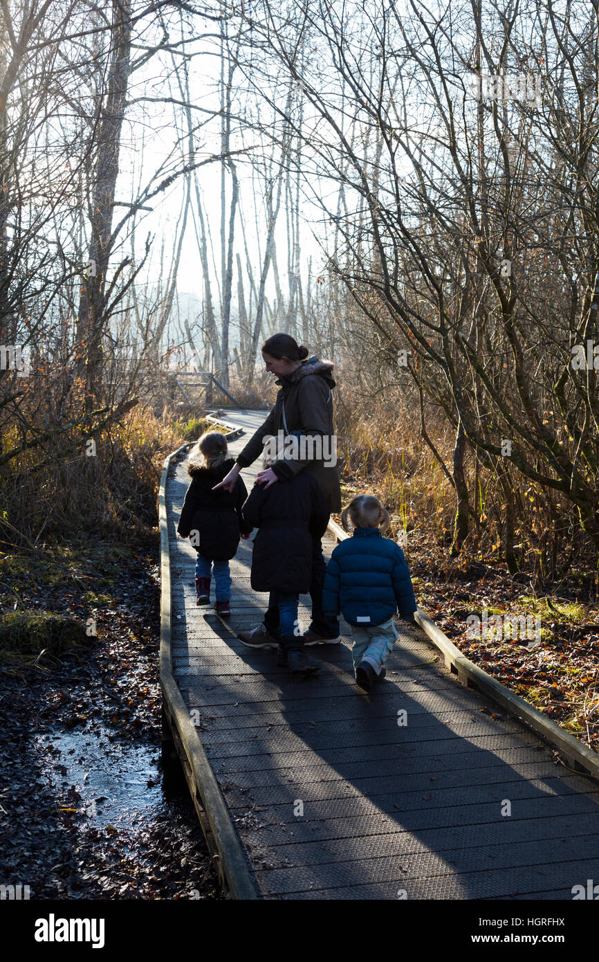 Mother & 3 children three kids daughters on walkway pathway foot path ...