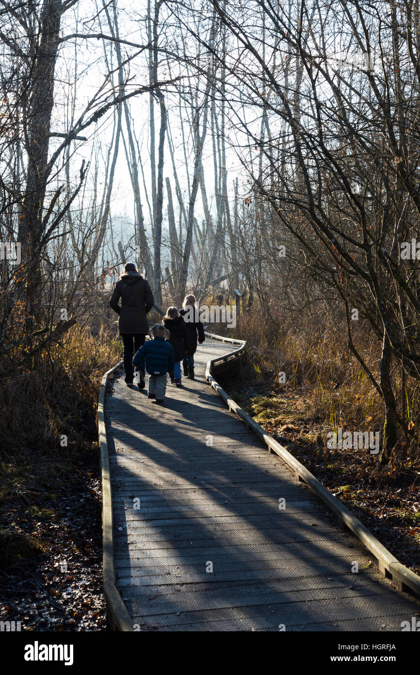 Mother & 3 children three kids daughters on walkway pathway foot path ...