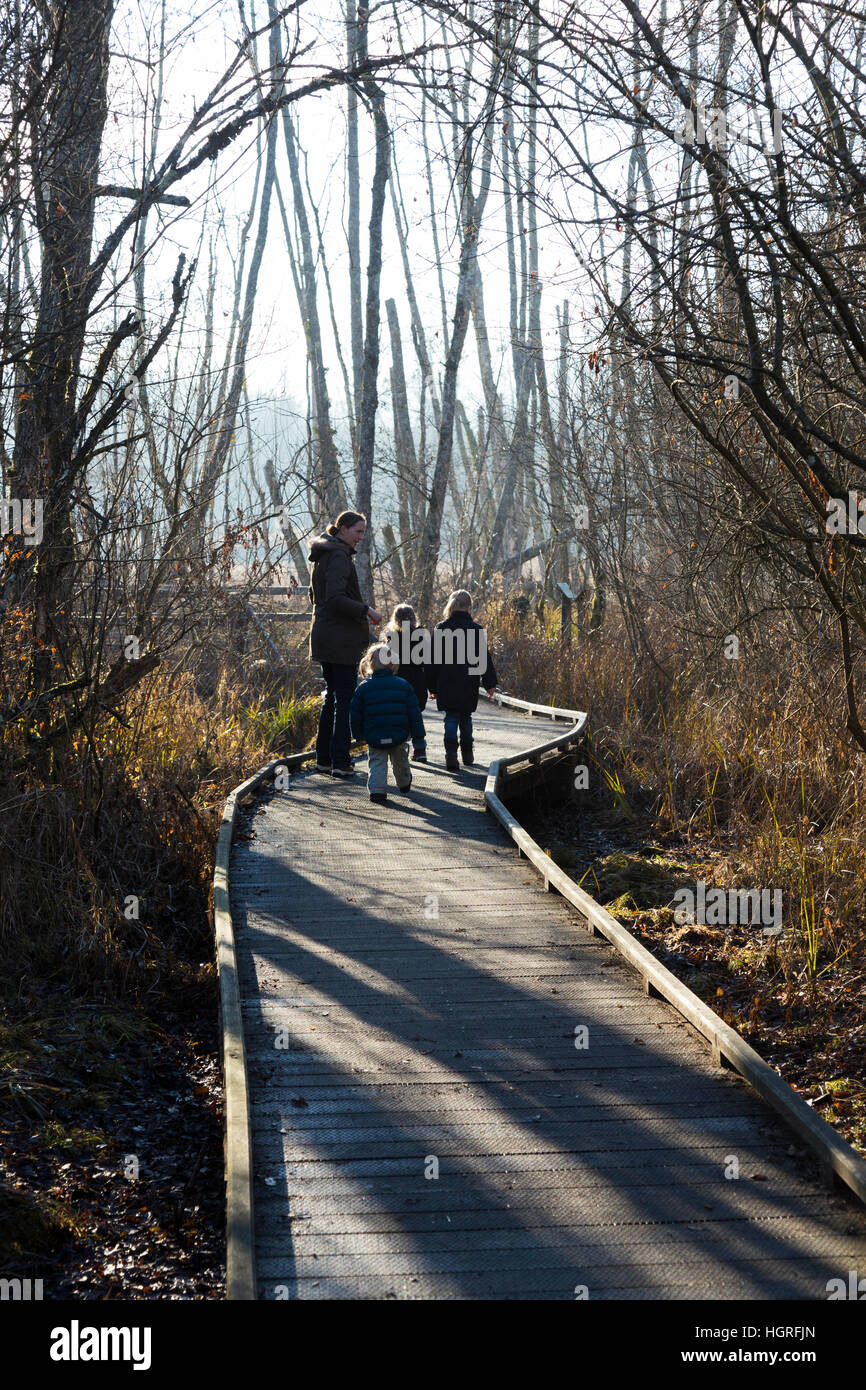 Mother & 3 children three kids daughters on walkway pathway foot path ...