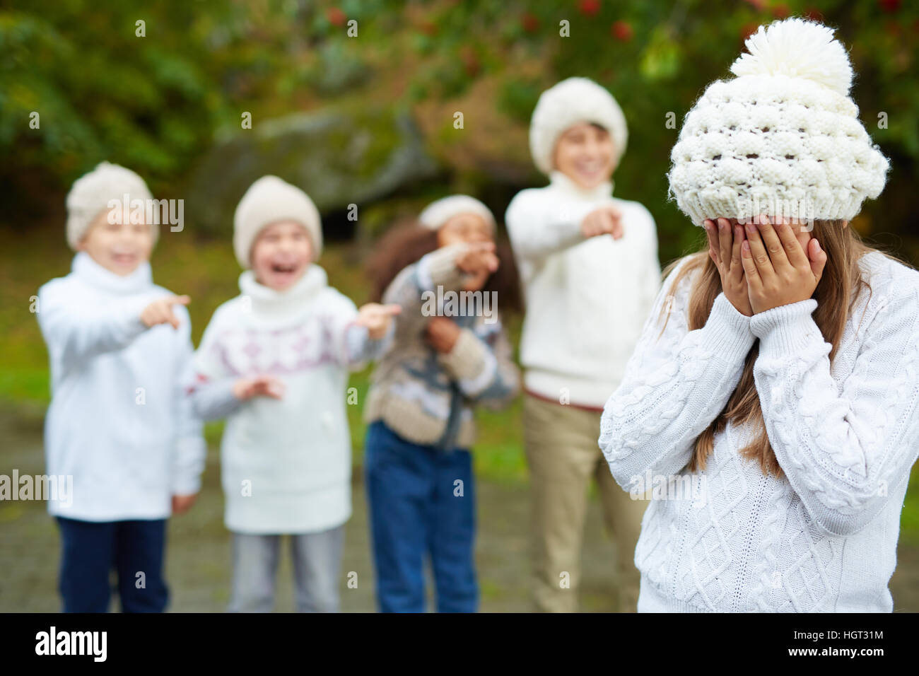 Crying girl hiding her face while classmates bullying her Stock Photo ...