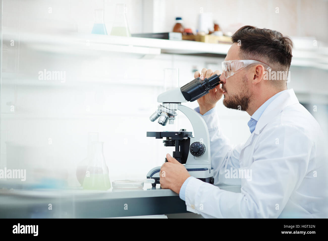 Contemporary scientist looking in microscope Stock Photo - Alamy