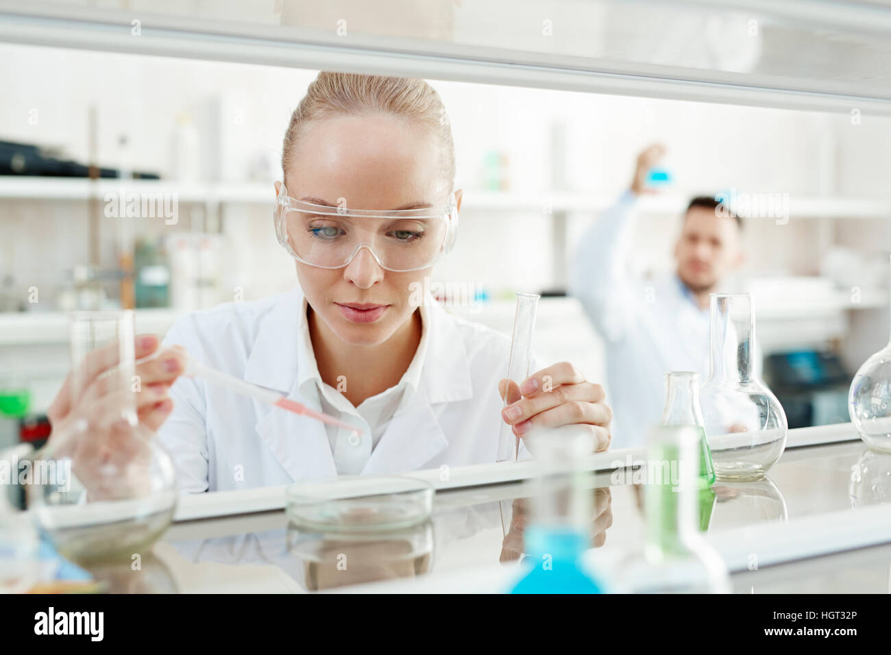 Female scientist with flasks studying new substance Stock Photo - Alamy