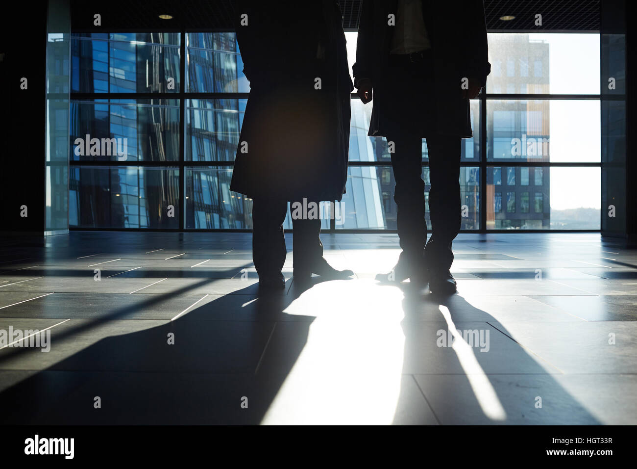 Low section of two businessmen standing inside office center Stock ...