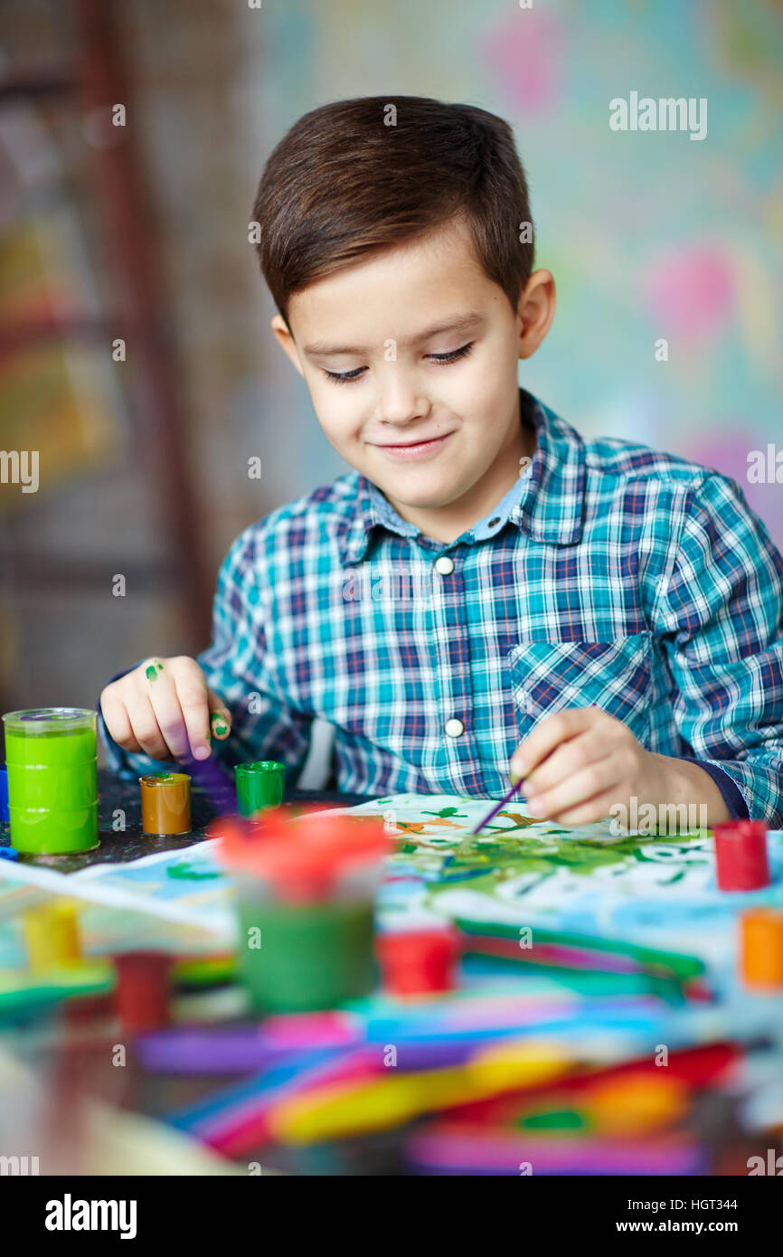 Cute boy painting with gouache and paintbrush Stock Photo - Alamy