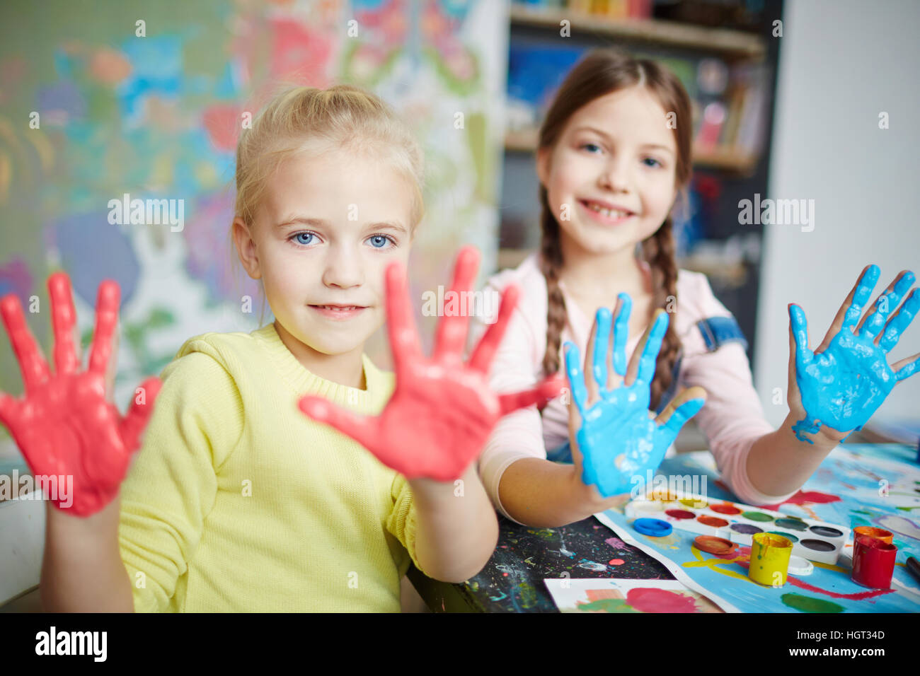 Girls with paint on palms having fun while drawing Stock Photo - Alamy