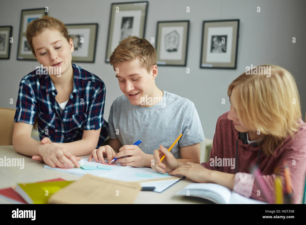 Friendly teens carrying out assignment in group Stock Photo - Alamy
