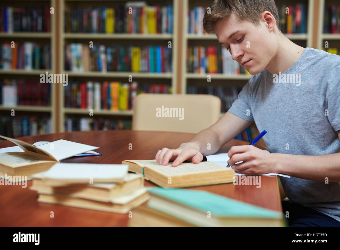 Serious guy rewriting information from book into his copybook Stock ...