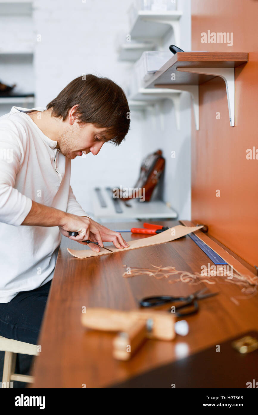 Owner of tanner workshop processing piece of leather Stock Photo - Alamy