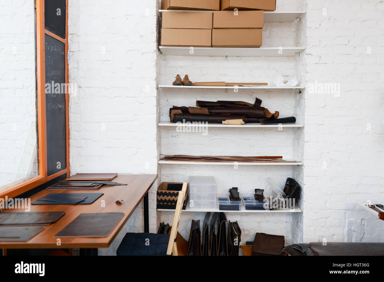 Empty workroom of tanner with leather workpieces and boxes on shelves ...