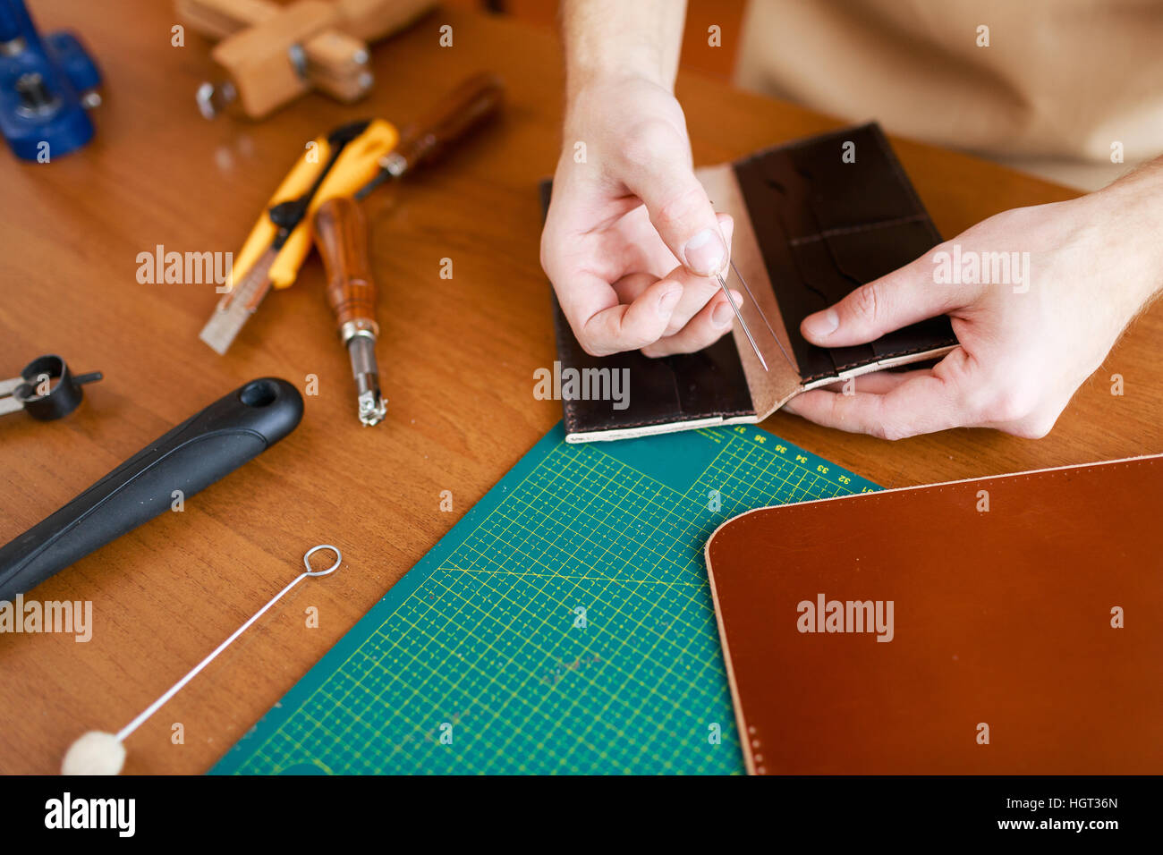 Human hands stitching leather wallet Stock Photo - Alamy