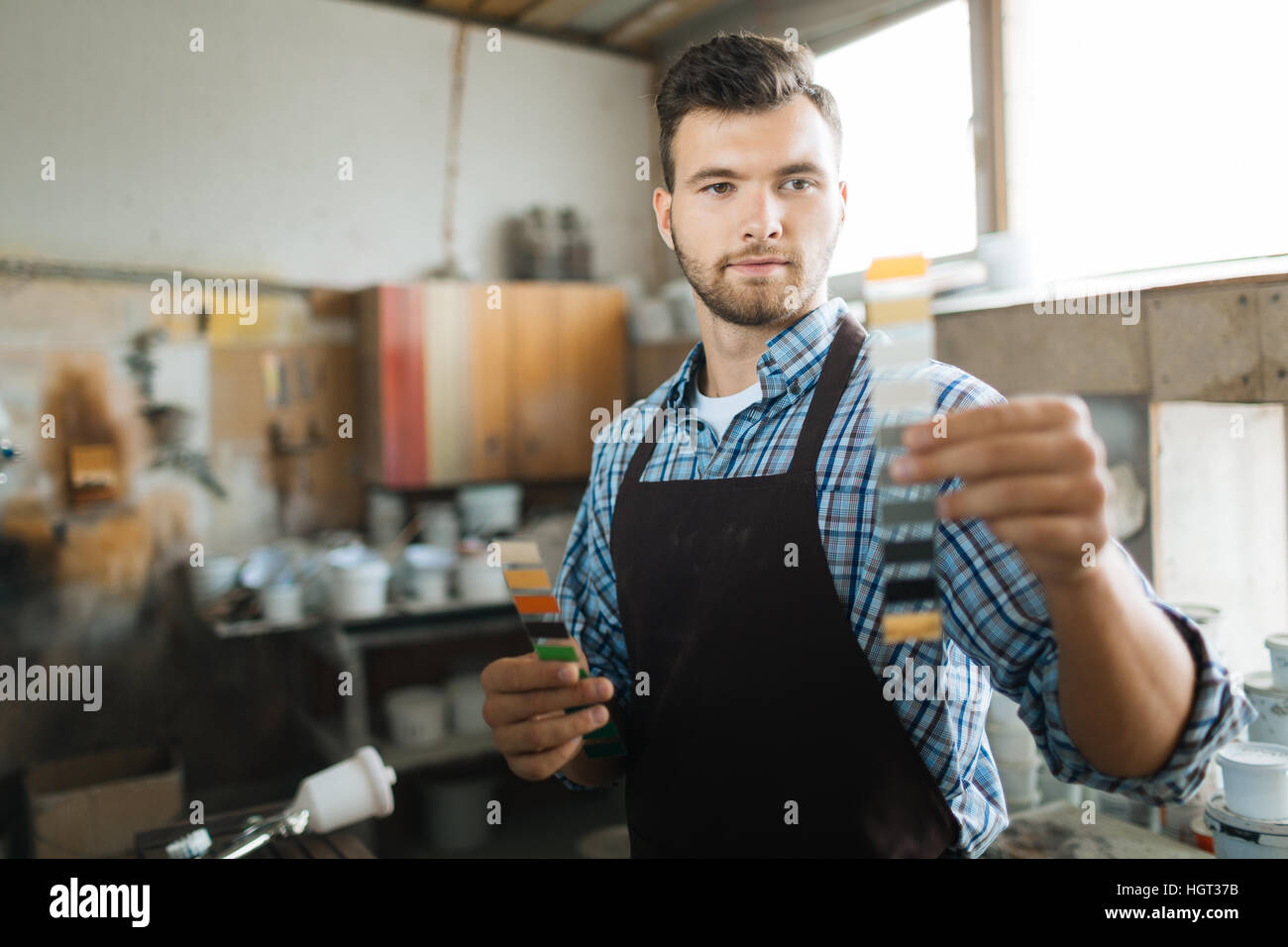 Creative man looking at color chart in workshop Stock Photo - Alamy